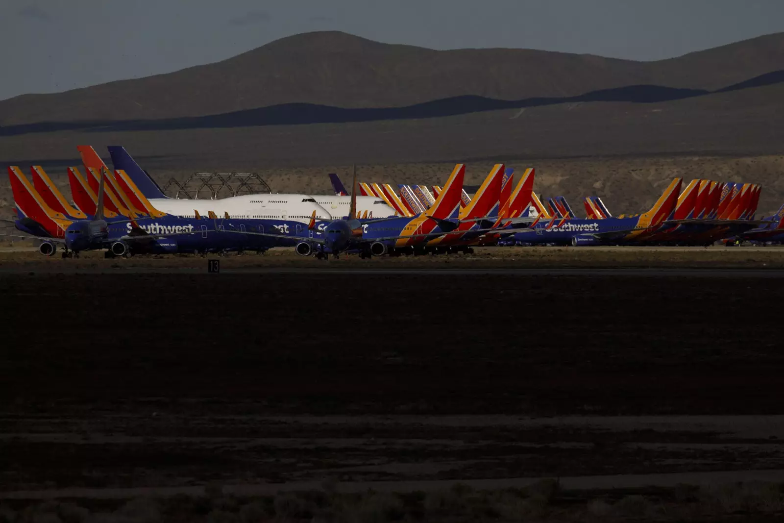 Flugzeuge der Southwest Airlines Co. stehen am Montag, den 23. März 2020, auf einem Feld in Victorville, Kalifornien, USA, geparkt. Southwest, das die meisten Passagiere auf den Inlandsmärkten befördert, sagte, es werde ab Sonntag 1.000 tägliche Flüge kürzen, vor einem zuvor geplante Kapazitätsreduzierung um 20 % aufgrund eines raschen Rückgangs der kurzfristigen Nachfrage. (Foto von Patrick T. Fallon/Bloomberg/Getty Images)