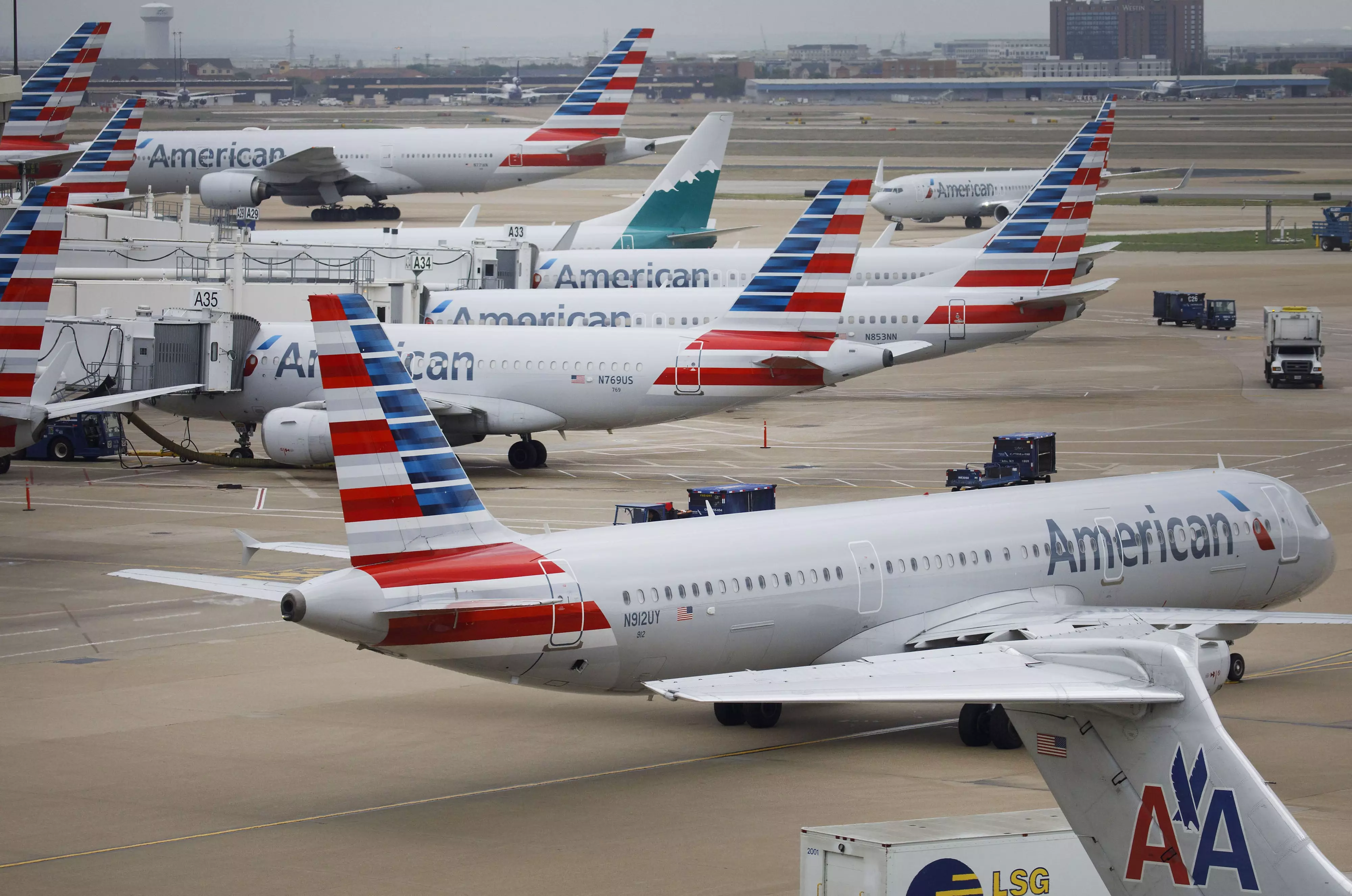 pesawat Amérika Airlines Grup Nyarita nangtung di Bandara Internasional Dallas-Fort Worth (DFW) di Grapevine, Texas, AS, Jumaah 6. April 2018. American Airlines dijadwalkeun pikeun ngaleupaskeun inohong earnings on April 26. Fotografer: Patrick T. Fallon /Bloomberg via Getty Gambar