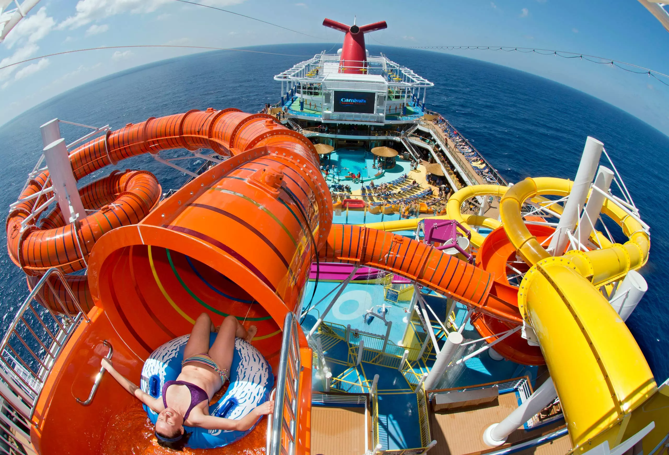 Passiġġier fuq il-Carnival Vista ta' Carnival Cruise Line jipprepara biex jiżżerżaq 'l isfel mill-Kaleid-O-Slide tal-vapur. L-attrazzjoni tat-tubu tal-ilma hija parti miż-żona tal-waterpark tal-WaterWorks tal-bastiment. (Ritratt minn Andy Newman/Karnival Cruise Line)