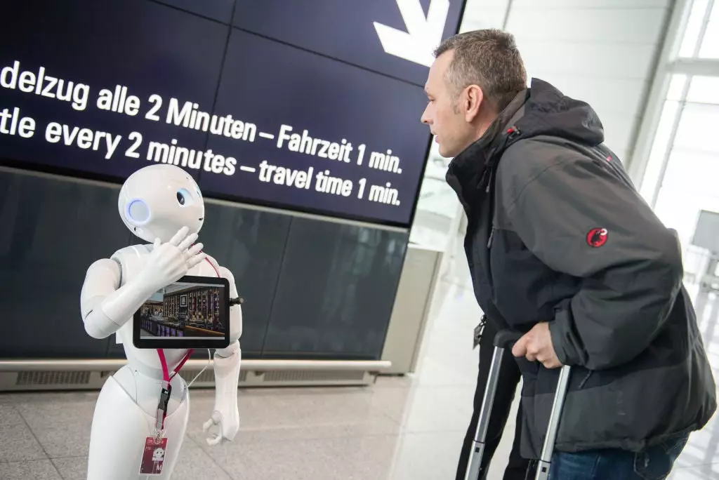 Robot Josie Pepper wuxuu caawiyaa rakaabka ka safraya garoonka diyaaradaha ee Munich, Jarmalka, 20 Febraayo 2018. Pepper waa aalad bini'aadanti ah oo loo qorsheeyay in lagu falanqeeyo oo lagu daydo dhaqdhaqaaqyada aadanaha iyo muuqaalka wejiga. Sawirka: Lino Mirgeler/dpa (Sawirka Lino Mirgeler/isbahaysiga sawirka ee loo sii marayo Getty Images)