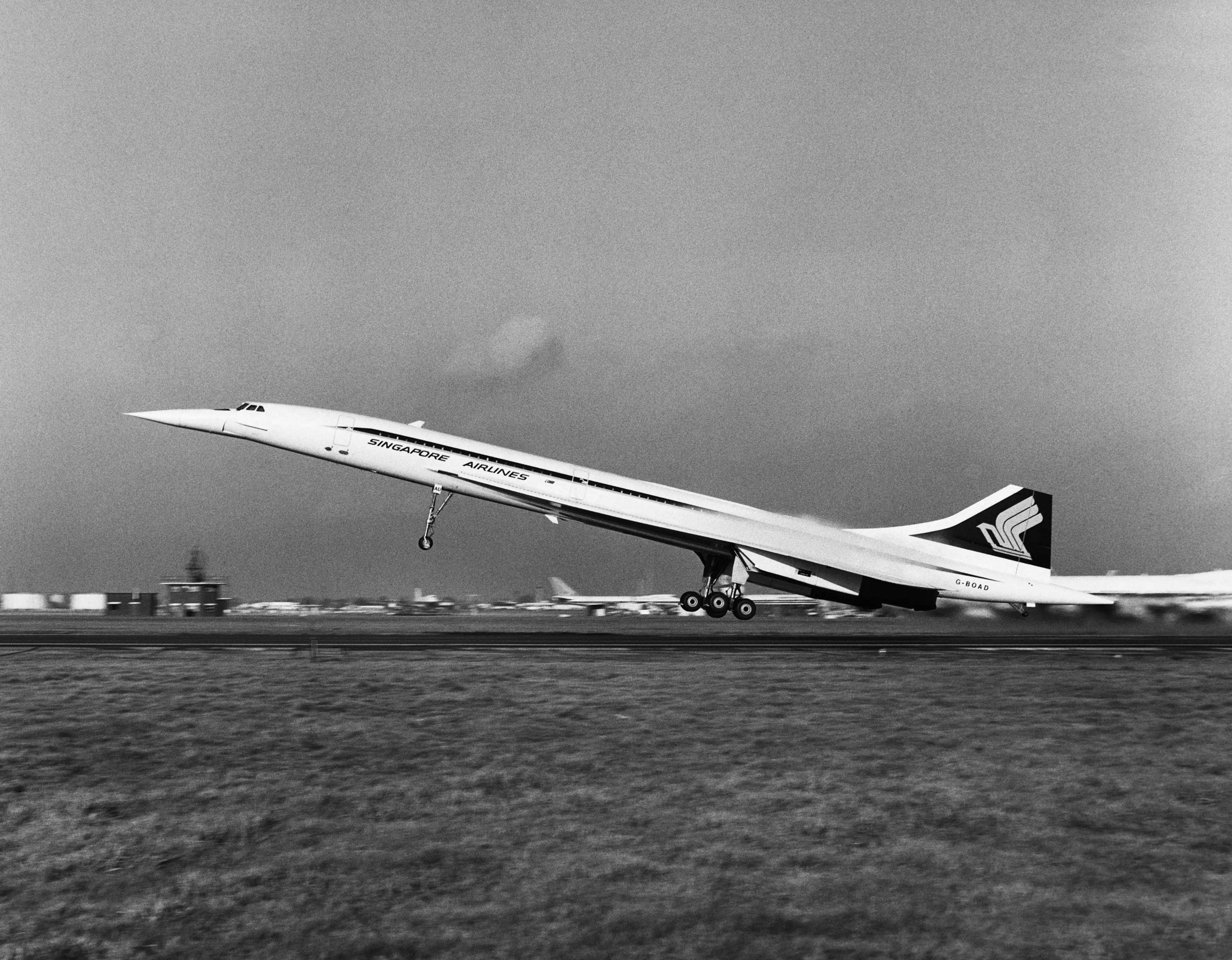 Éiríonn aerárthach Concorde 210 as Aerfort Heathrow i Londain. Tá an t-eitleán, a bhfuil sreabhra Singeapór Airlines péinteáilte ar thaobh amháin agus ceann British Airways ar an taobh eile, ag oibriú an chéad chomhsheirbhís aerlíne go Singeapór, trí Bairéin. (Grianghraf le © Hulton-Deutsch Collection/CORBIS/Corbis trí Getty Images)