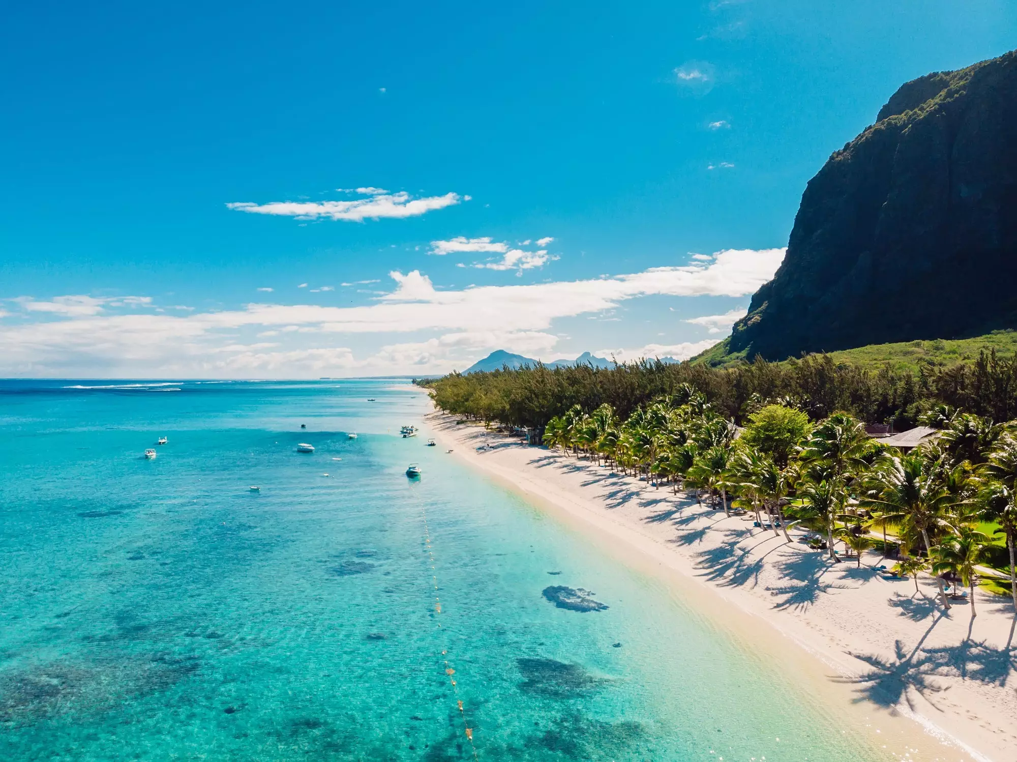 Luksusstrand med fjell i Mauritius. Sandstrand med palmer og blått hav. Luftfoto (Foto av Nuture/Getty Images)