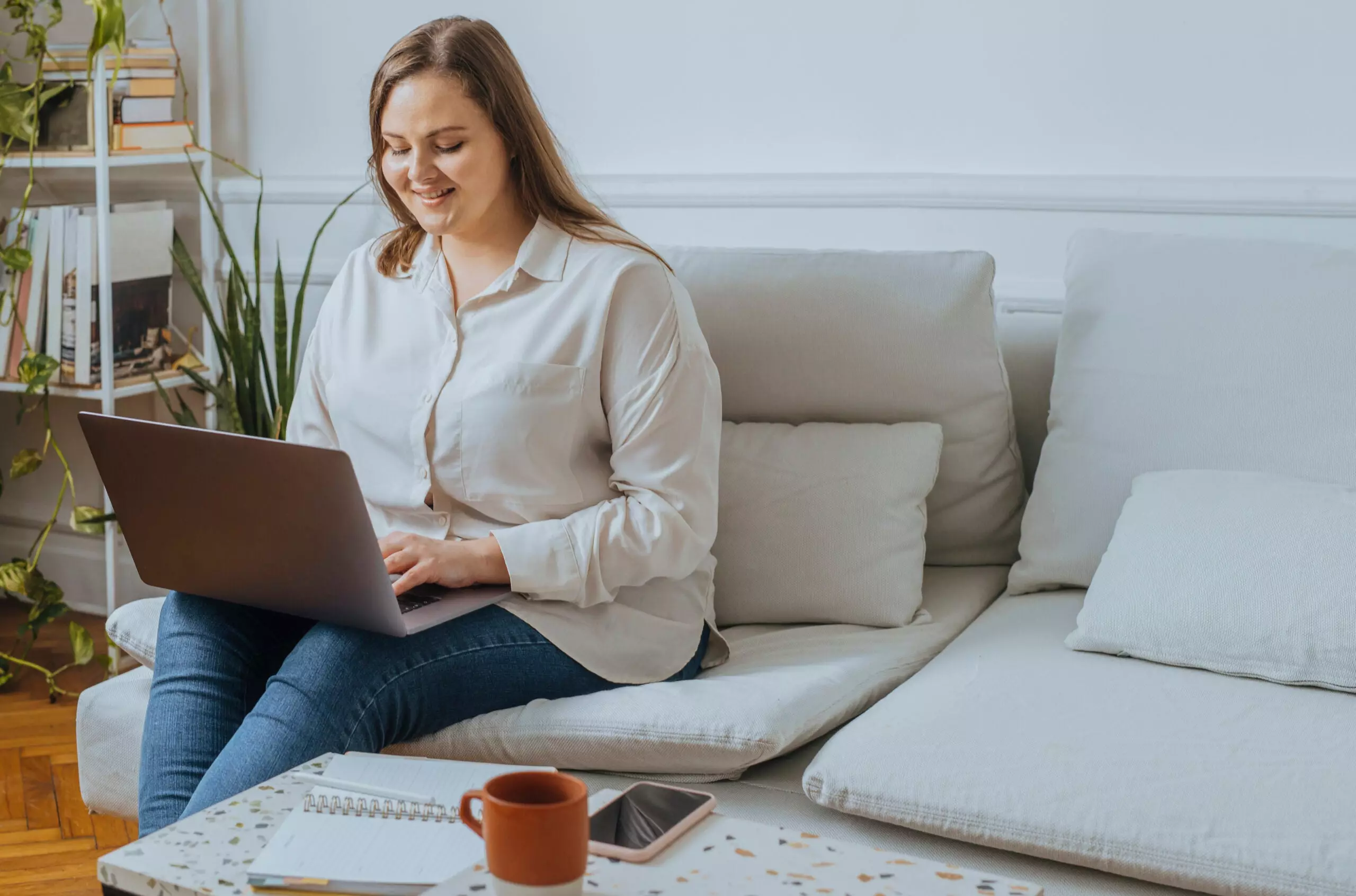 Frau, die zu Hause an ihrem Laptop-Computer arbeitet