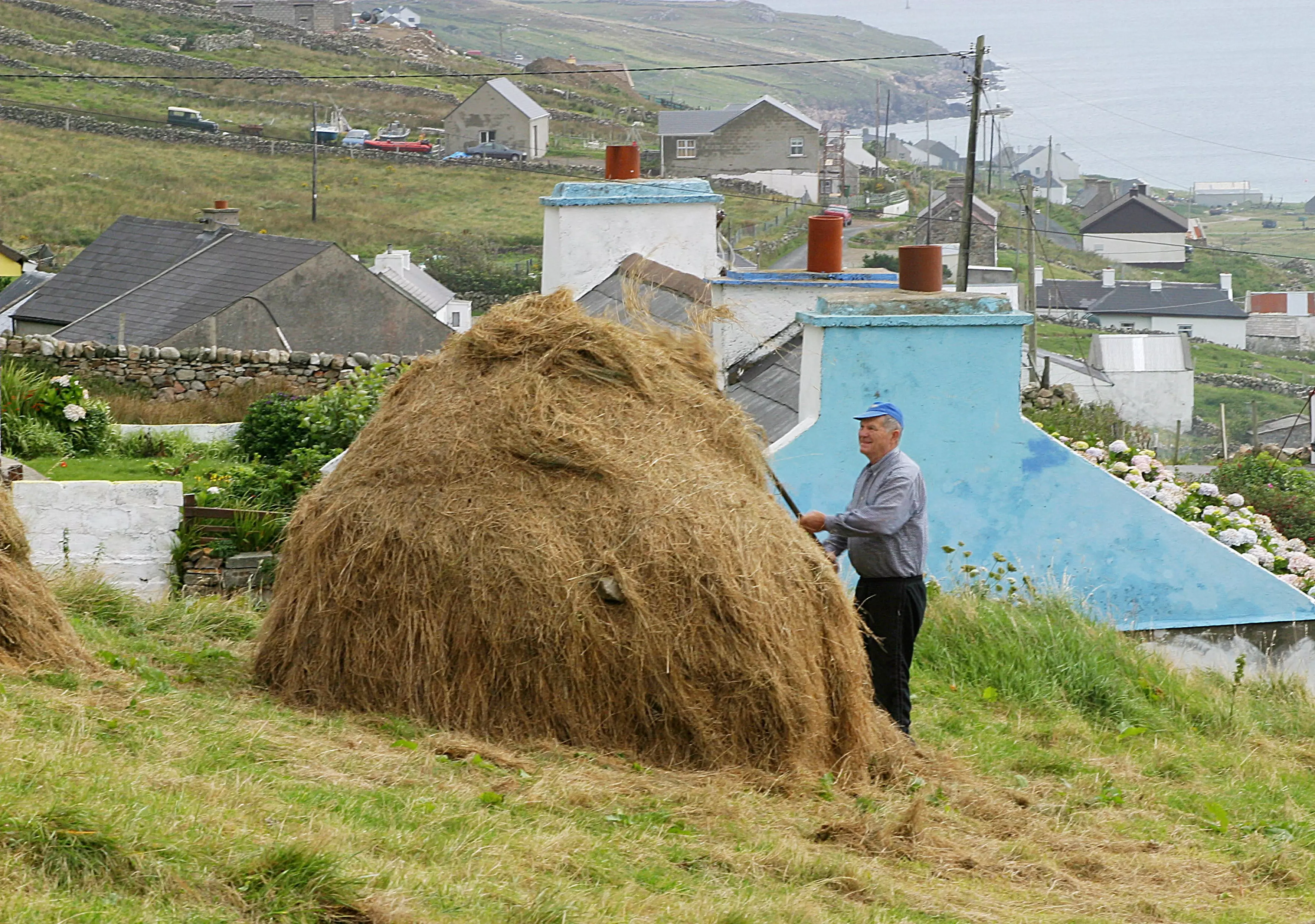 IRLANDE - VERS 2004 : Île d'Arranmore, Irlande en 2004 - Il ne se passe pas grand-chose sur l'Île : la mer, vidée de toutes ses richesses par la surpêche, est presque dépourvue de poissons ; seule une poignée d'habitants pêchent encore, principalement de façon saisonnière et en petit barque ; beaucoup de gros bateaux pourrissent sur l'île ; Les gens d'Aranmore ont toujours immigré en Écosse ou dans le nord de l'Angleterre ; beaucoup d'entre eux reviennent pour construire une nouvelle maison ou réparer la maison ancestrale ; c'est un peuple incroyablement sympathique ; pendant la famine, trois cents d'entre eux furent chassés par le propriétaire et déportés au Canada ; ils sont partis le 24 avril 1851 et sont arrivés à Québec le 5 juin de la même année ; aucun d'eux n'est mort en transit ; à l'été 1856, la plupart s'installèrent dans l'île Beaver sur le lac Michigan ; en mars 2003, une centaine d'habitants de Beaver island sont revenus pour la première fois à Aranmore pour le jumelage des deux îles - C'était très émouvant. (Photo de NUTAN/Gamma-Rapho via Getty Images)