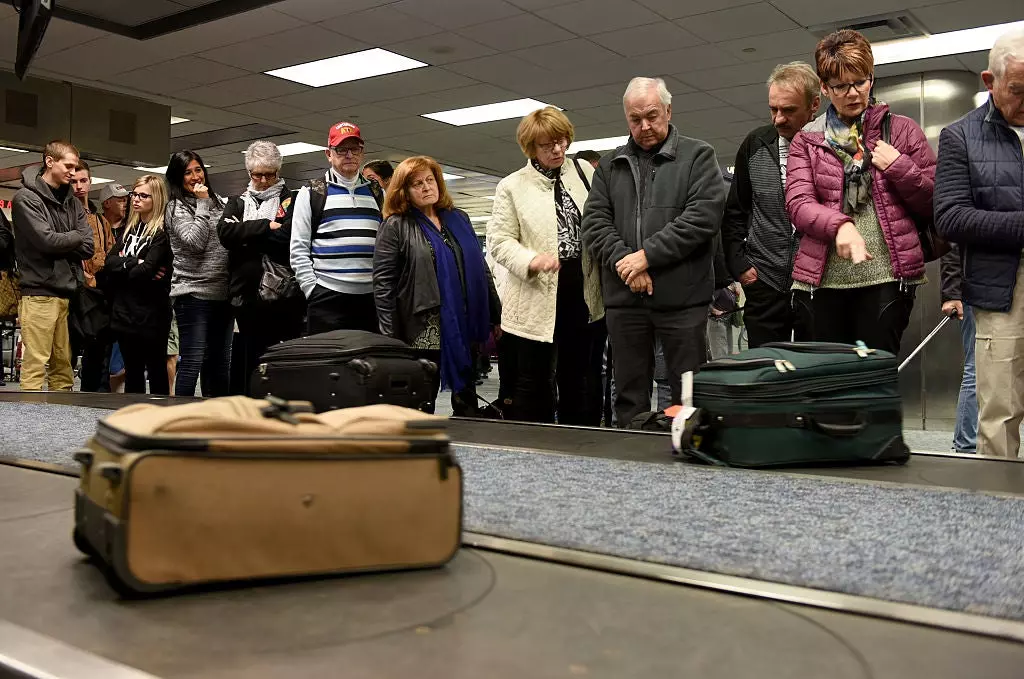 Penumpang Air Canada ngadeg ing carousel bagasi Terminal 2 nggoleki bagasi ing dina Minggu, 8 Januari 2017, ing Bandara Internasional Fort Lauderdale-Hollywood. Area bagasi Terminal 2 tetep dibukak sebagian Minggu. (Taimy Alvarez/Sun Sentinel/TNS liwat Gambar Getty)