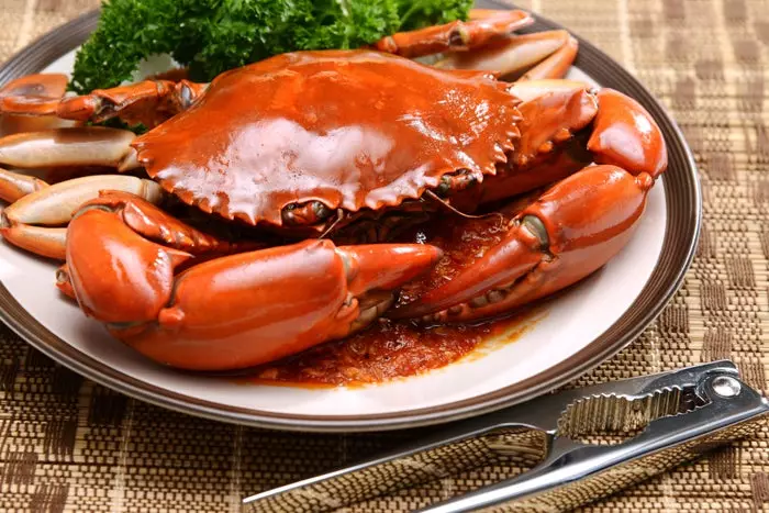 Singaporean chili crab yog maj mam simmered nyob rau hauv ib tug ntsim, qab zib-savory sauce rau pom tsw. Diam duab courtesy of Shutterstock.