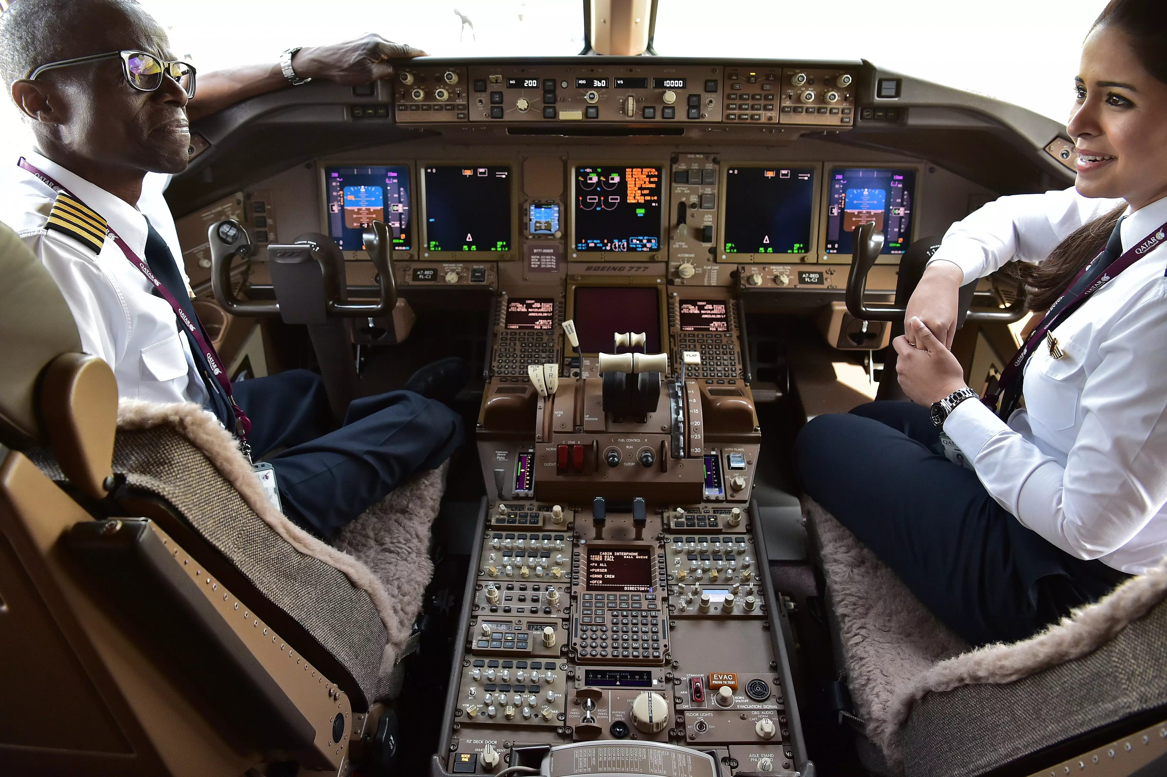 Ireo mpanamory Qatar Airways dia niresaka tao amin'ny kabin'ny fiaramanidina Boeing 777 naseho tao amin'ny International Paris Air Show tao Le Bourget ivelan'i Paris tamin'ny 22 Jona 2017. / AFP PHOTO / CHRISTOPHE ARCHAMBAULT )